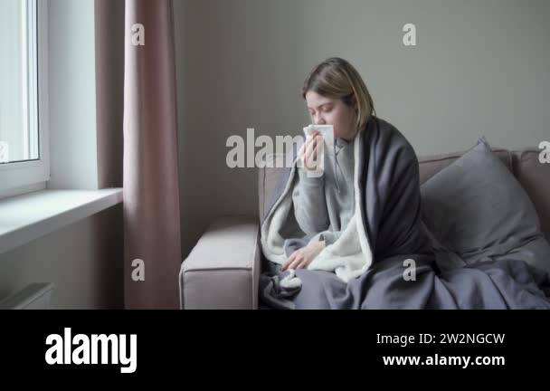 A girl with tired eyes sits opposite the onk. He is sick and blows his ...