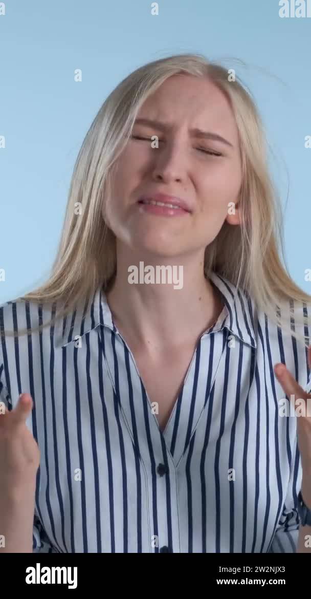 Desperate and angry woman spreading her hands to the sides and crying ...