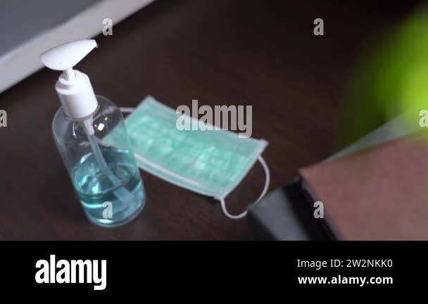Asian male hand use sanitizer gel then rubbing hands, wood desk, green ...