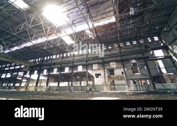 Ruined plant interior with pitted roof and the sun shines inside. Empty ...