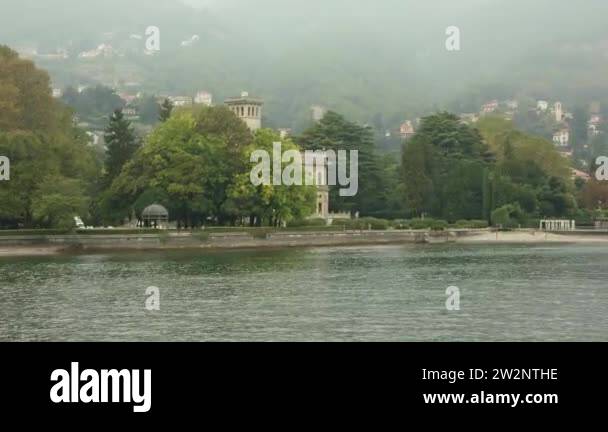 A beautiful view opens from a boat on Villa Erba among large trees on ...