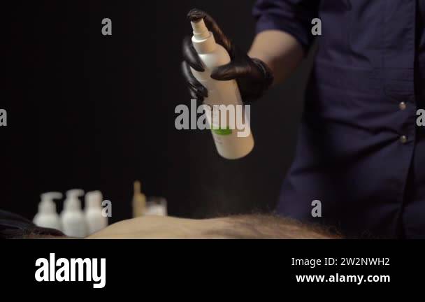 The depilation master applies a special lotion to the male body before ...