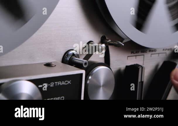 Man hands include rewind on vintage professional analog reel-to-reel ...