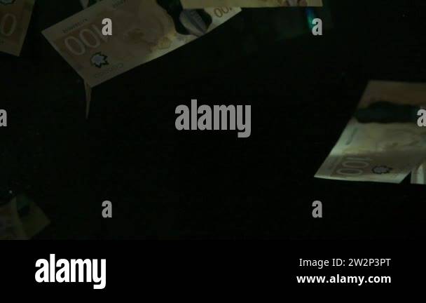 Falling flying american canadian dollar banknotes on a black background ...