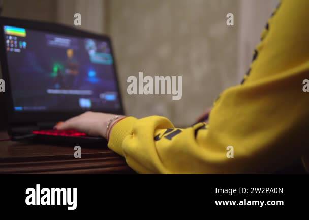 Girl gamer playing video game, shooter, gaming laptop, back view over ...