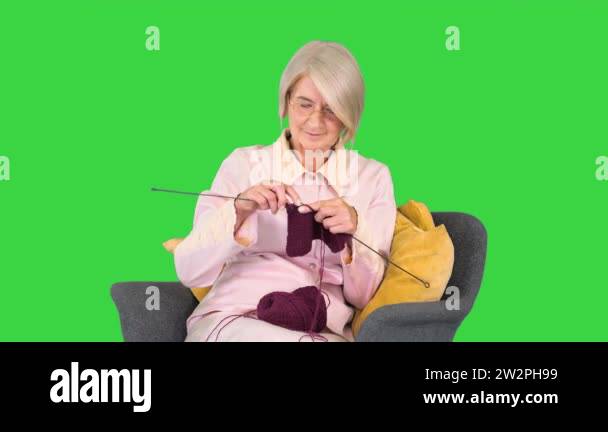 Elderly woman knitting woolen clothes on a Green Screen, Chroma Key ...