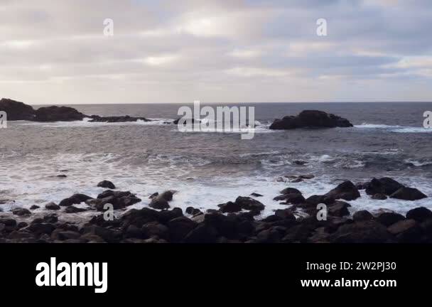 Endless ocean waves crashing on pictorial grey rock with white foam in ...