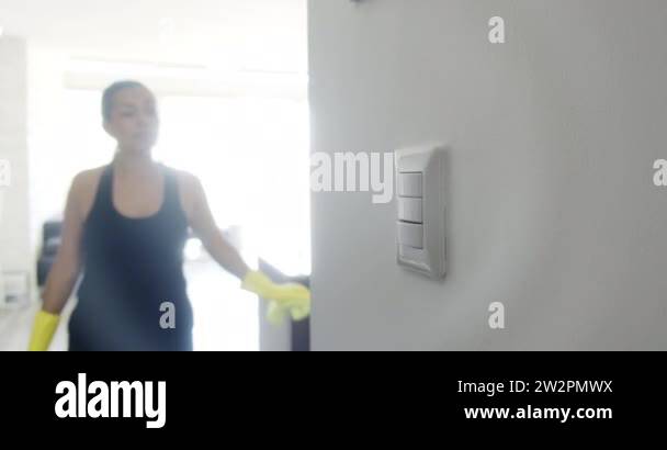Close up view of woman wiping electrical and light switch at home ...