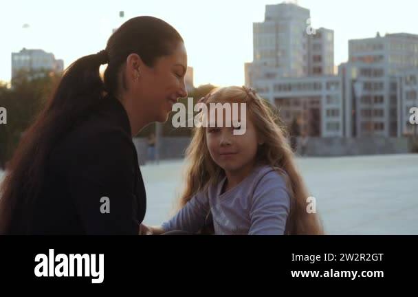 Close up older sister or mother hugs her daughter schoolgirl girl ...