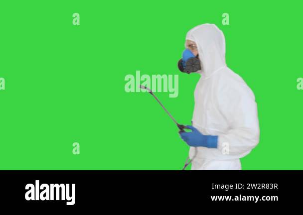 Man wearing an NBC personal protective equipment spray disinfectant and ...