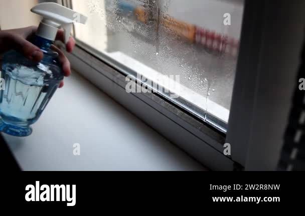 Men washes windows in home. Cleaning window with a wash spray and a ...