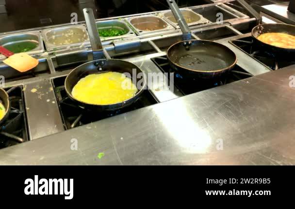Cooking omelettes and fried eggs. Breakfast buffet in restaurant in ...