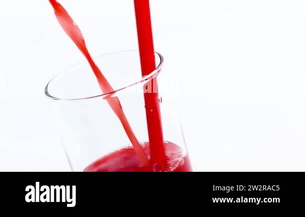 Detail of pouring red orange juice isolated into glass on white ...