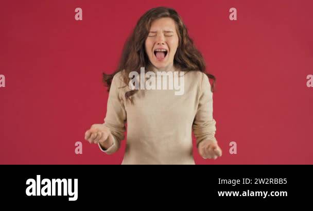 Caucasian young woman teenager girl stands posing on red background in ...