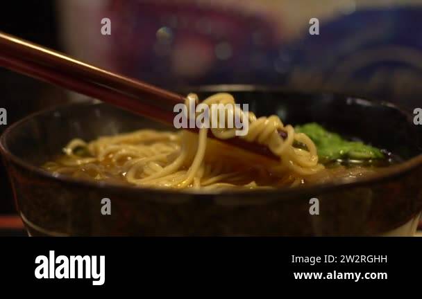 Slow motion people eating a bowl of beef noodles for dinner in an asian ...