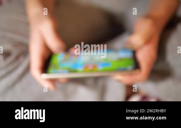 hands of a girl playing video games with a modern smartphone. touch ...