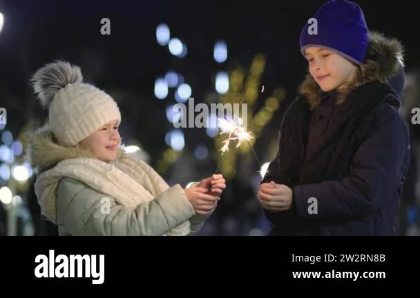 Two cute young children, boy and girl in warm winter clothing holding ...