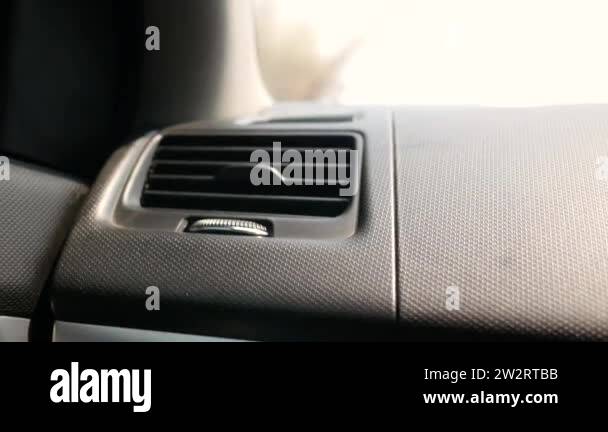 Close-up of passenger hand tuning air ventilation grille or adjusting ...