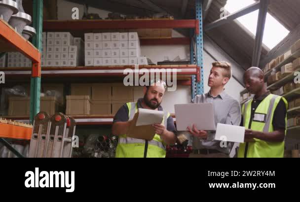 Two Caucasian and an African American male factory worker at a factory ...