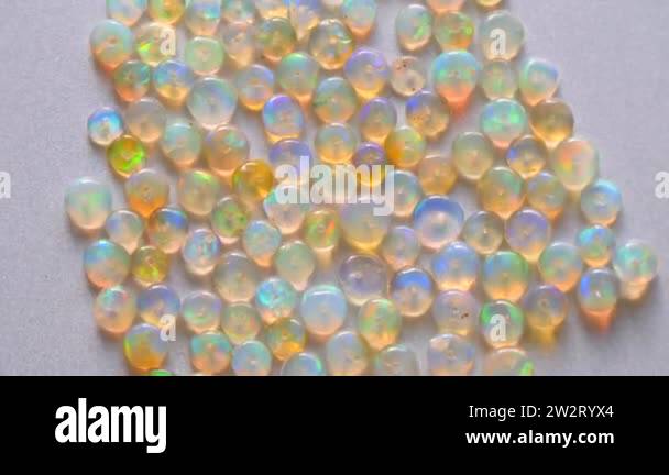 Opals gemstone from Ethiopia rotates on light background. White fire ...