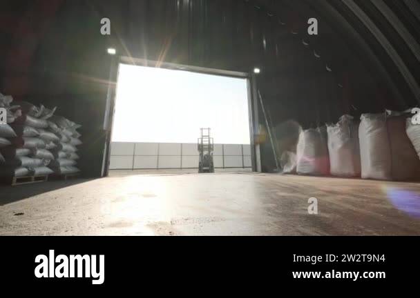 Warehousing. Forklift driver stacking big bag of raw material in ...