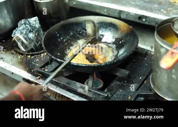 Indian bread paranthas being deep fried in hot oil. Street food in ...