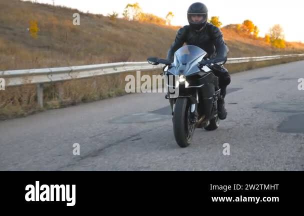 Man in helmet riding on modern sport motorbike at highway. Motorcyclist ...