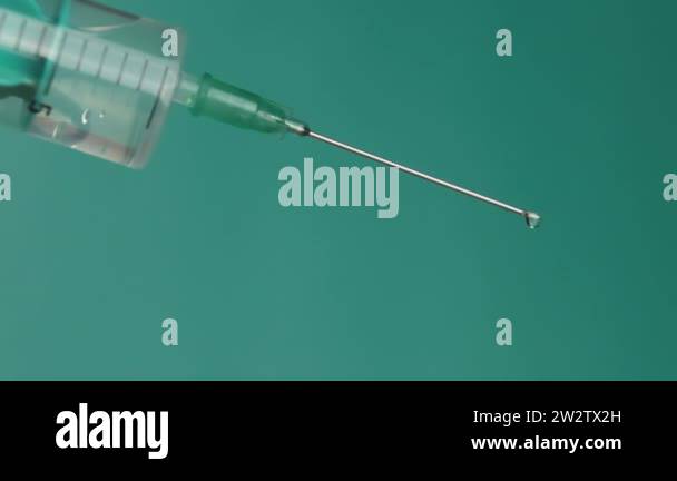 Syringe Needle with Liquid Dripping Drops of Medication in Slow Motion ...