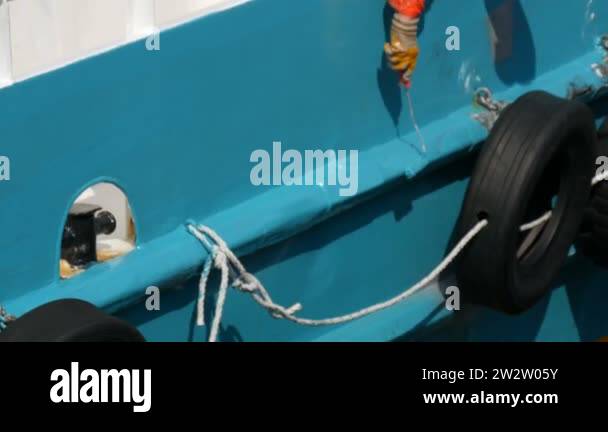 Hand of a man of a sailor paints with a paint with a roller stern of ...