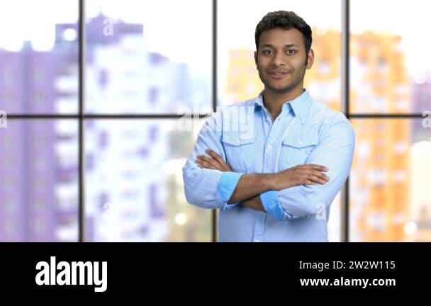 Young brown-skinned man with folded arms pointing back with thumb Stock ...