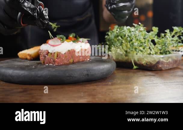 Close-up shot of chef adding micro greens for cooking. Micro greens on ...