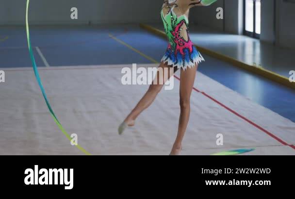 Side view of focused teenage mixed race female gymnast performing at ...