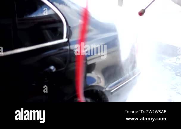 The process of washing a BMW business class car, rinsing the foam from ...