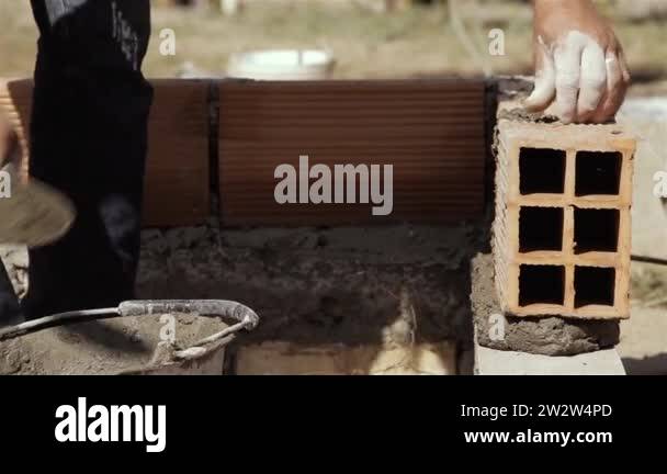 Construction Worker building a Brick Wall with a Spatula and a Cement ...