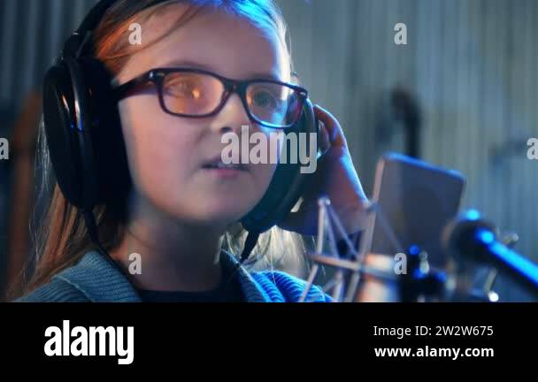 Kid singing in studio.Little girl singing a song.Front view close up ...