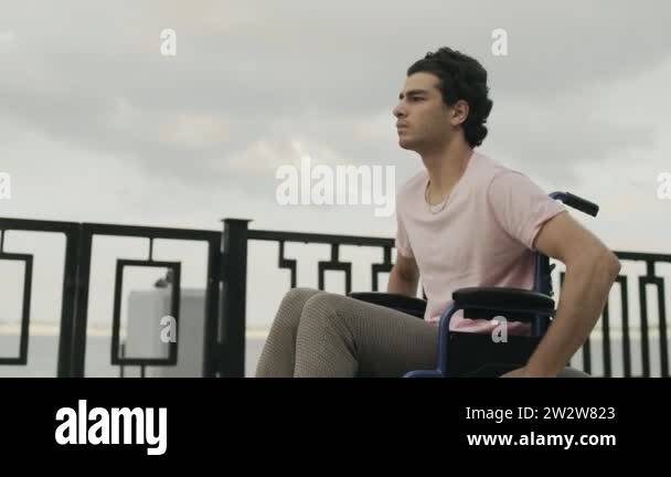 The unhappy man ride a wheelchair. Sad disabled rides in a wheelchair ...