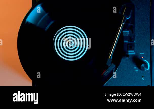 Top view of a vinyl turntable view top rotating with multicolored neon ...