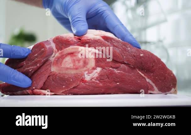 Butcher wearing Gloves on His Hands Preparing for Cutting a Big Piece ...