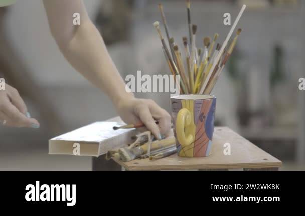 Artist making brushes for painting. Preparation of brushes and easel ...