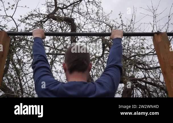 a man pulls himself up on a horizontal bar. charging.sport activities ...