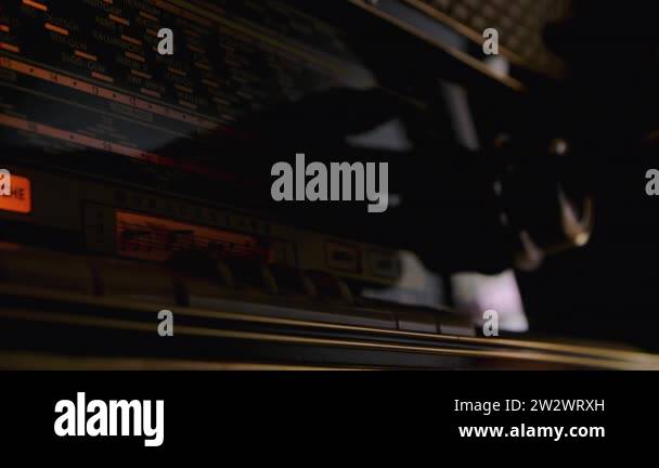 Bottom view men hands tune radio wave of an old antique radio receiver ...