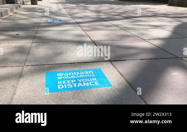 Painted blue sign with title "keep your distance" in english and ...