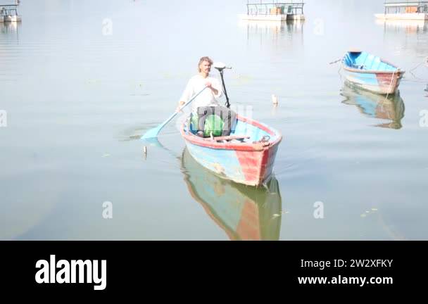 POKHARA, NEPAL - DECEMBER 7 : Nepalese people rowing wooden canoe boat ...