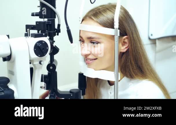 Young woman checking her eyes in clinic. Biomicroscopy device. Doctor ...