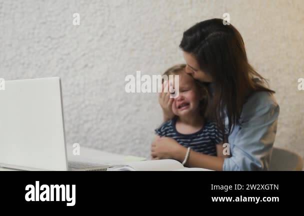 Young woman calms crying child in office. Woman works in office with a ...