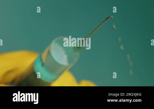 Syringe Needle with Liquid Dripping Drops of Medication in Doctor Hands ...