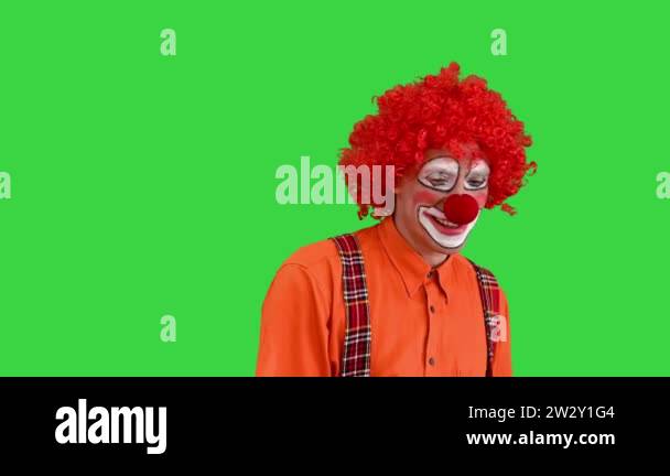 Shaking clown in love being shy and sending a kiss to camera on a Green ...