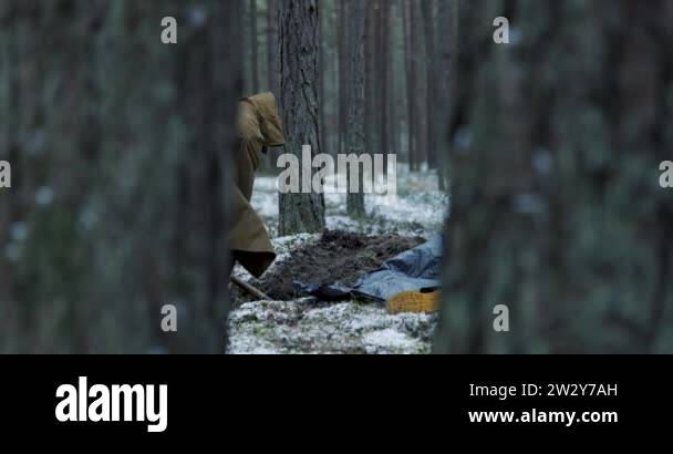 serial killer digs a grave in the woods at winter to hide the corpse ...