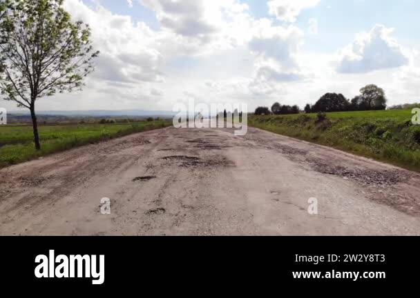 Destroyed roadway. Many pits and potholes in asphalt, no road markings ...