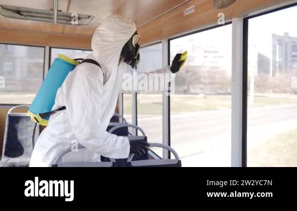 Hazmat team worker disinfects bus interior with antibacterial sanitizer ...